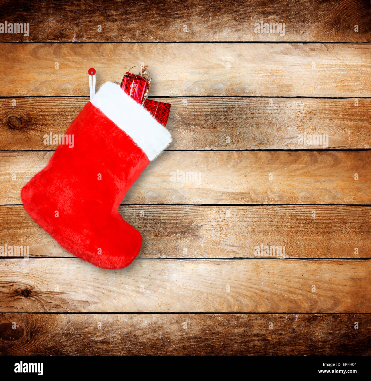Red christmas boot with gifts on background wooden wall Stock Photo - Alamy