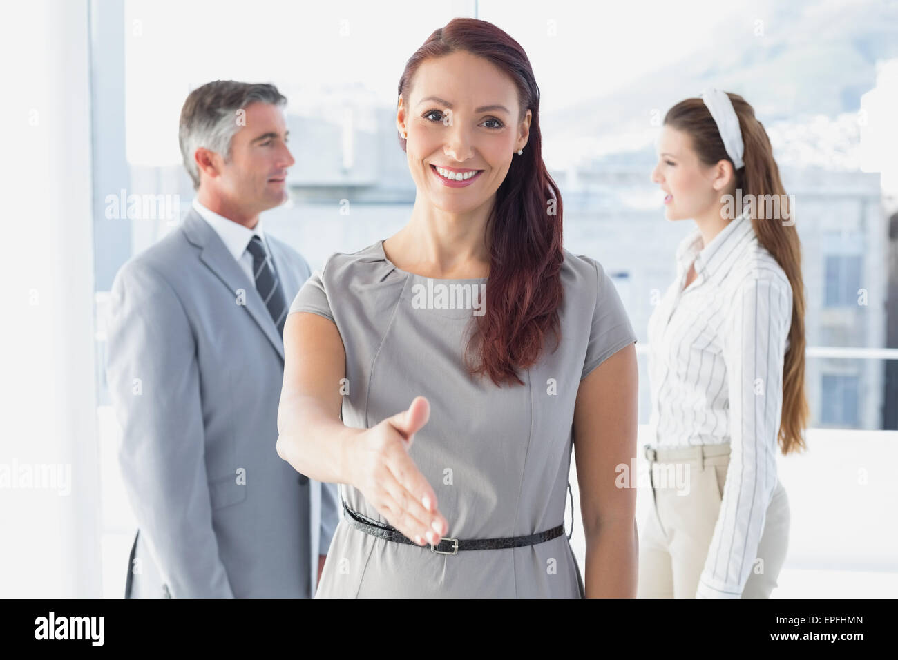 Smiling business woman offering handshake Stock Photo - Alamy