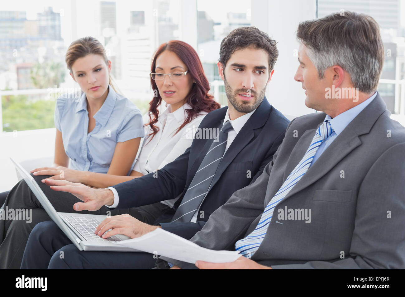 Business team looking at laptop Stock Photo - Alamy