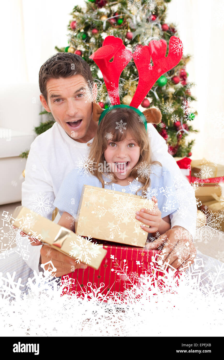 Composite image of surprised father and his girl opening christmas ...