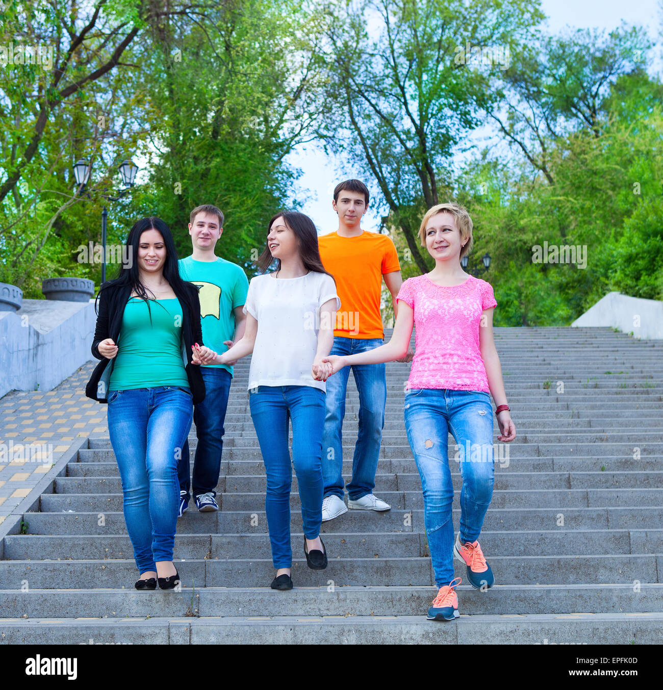 Smiling group of teenagers walking outdoors Stock Photo - Alamy
