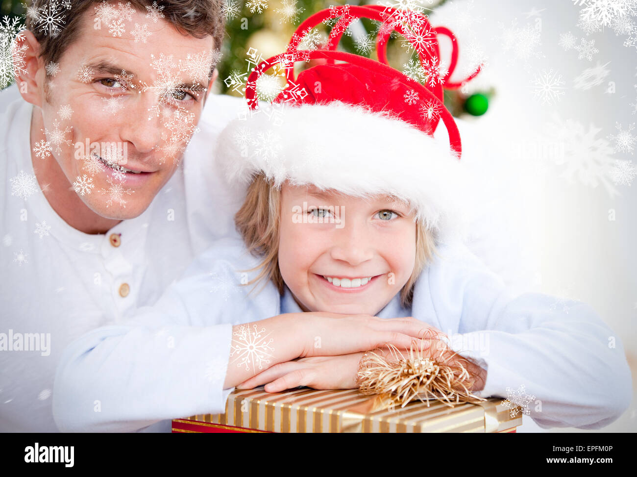 Composite image of bright father celebrating christmas with his son ...