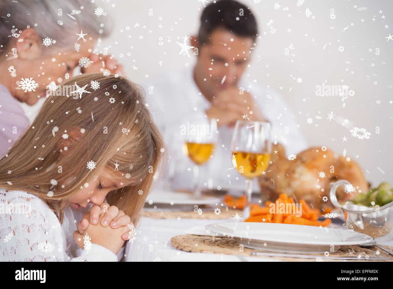 Composite image of little girl saying grace with family Stock Photo - Alamy