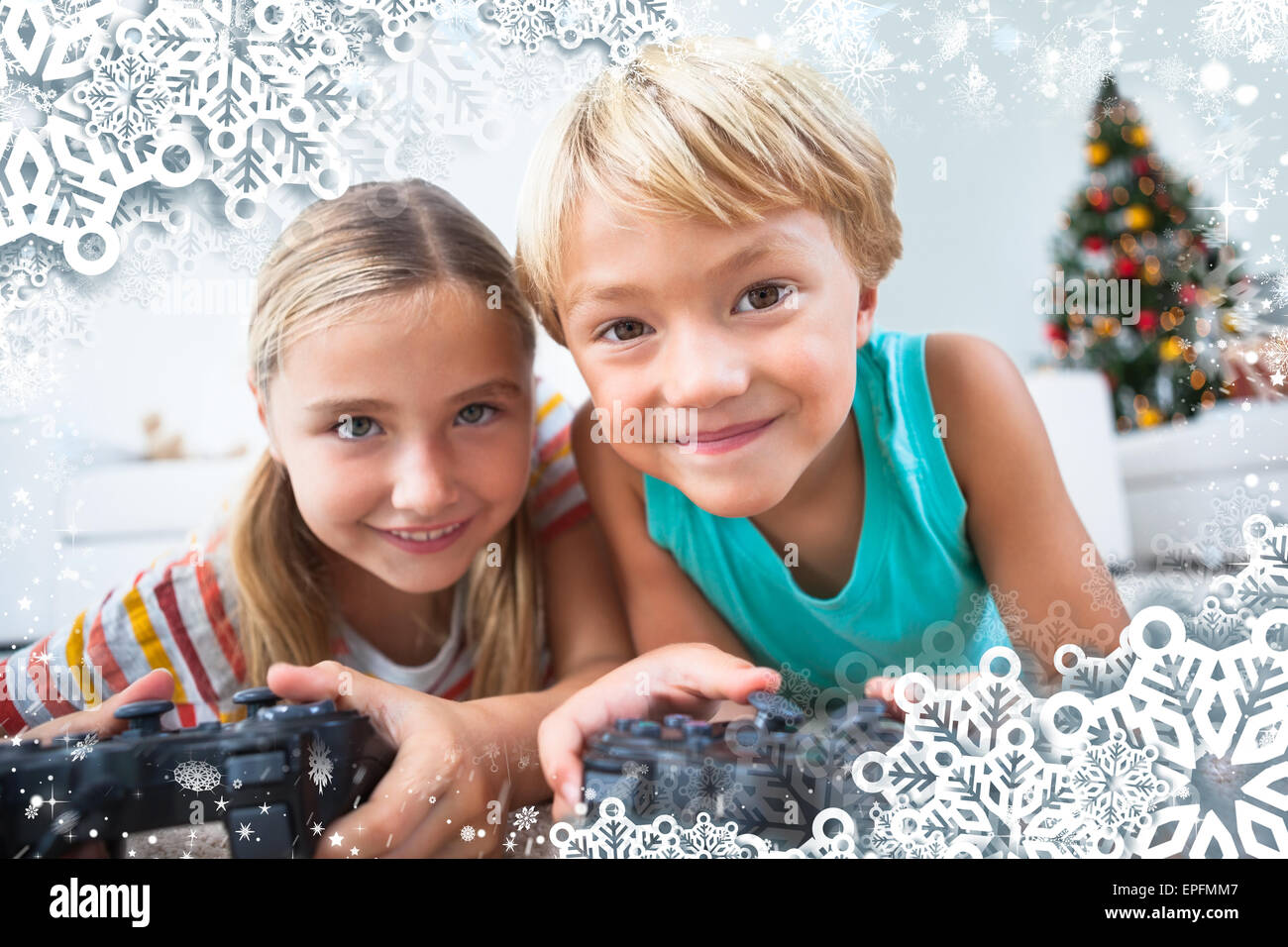 Composite image of happy siblings playing video games on floor Stock ...