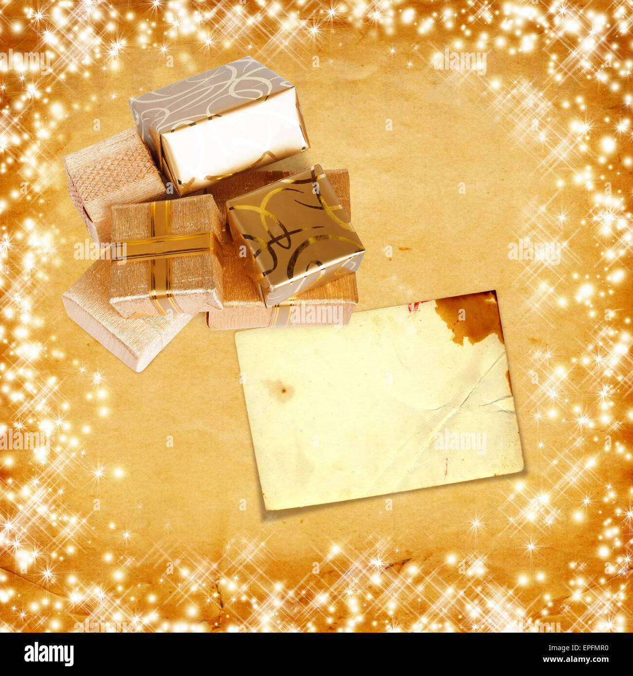 Gift box in gold wrapping paper on vintage cardboard background with ...