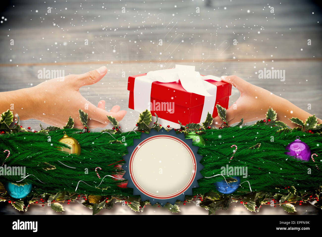 Composite image of couple passing a wrapped gift Stock Photo - Alamy