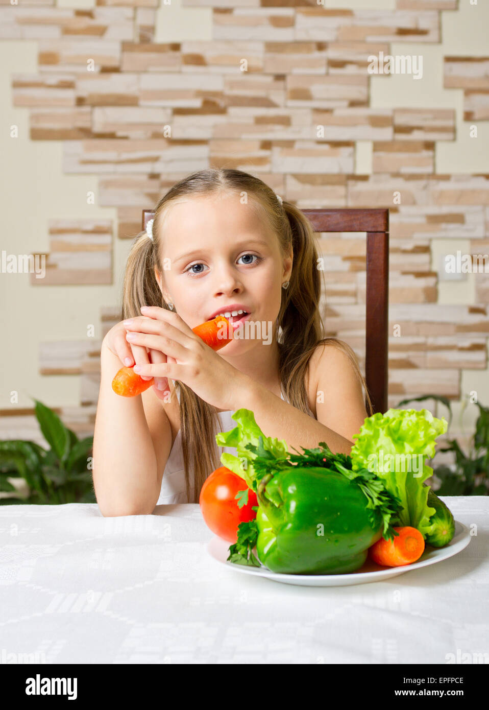Little girl with vegetables at light room Stock Photo - Alamy