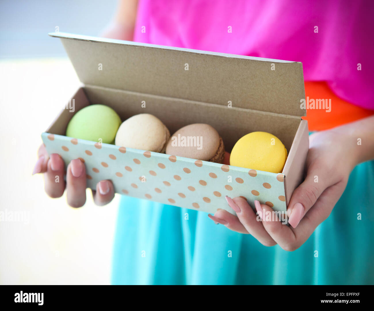 Girl holding colorful French macaroons in hands Stock Photo - Alamy