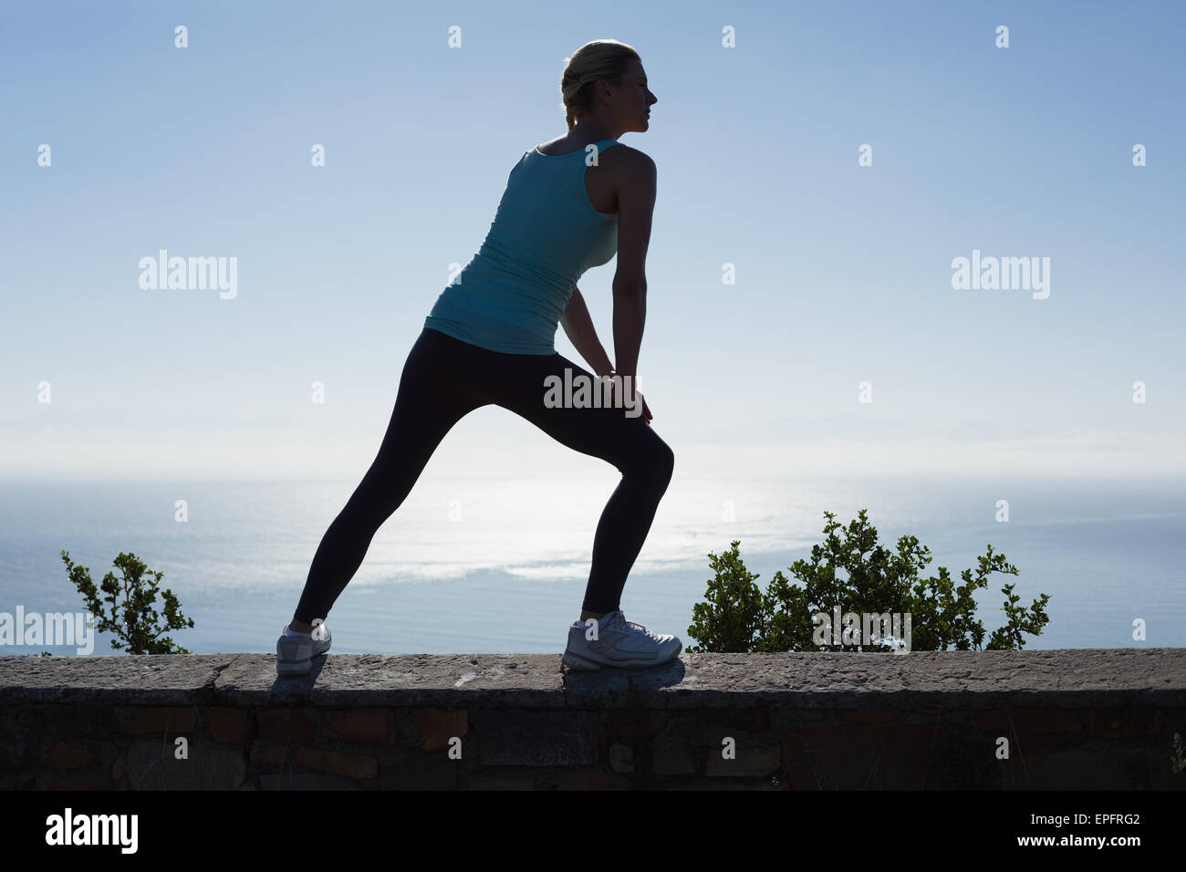 Fit woman stretching her legs looking out to sea Stock Photo - Alamy