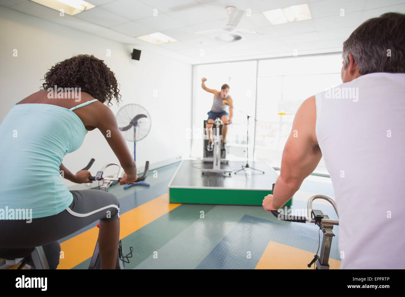 Spin class working out with motivational instructor Stock Photo - Alamy