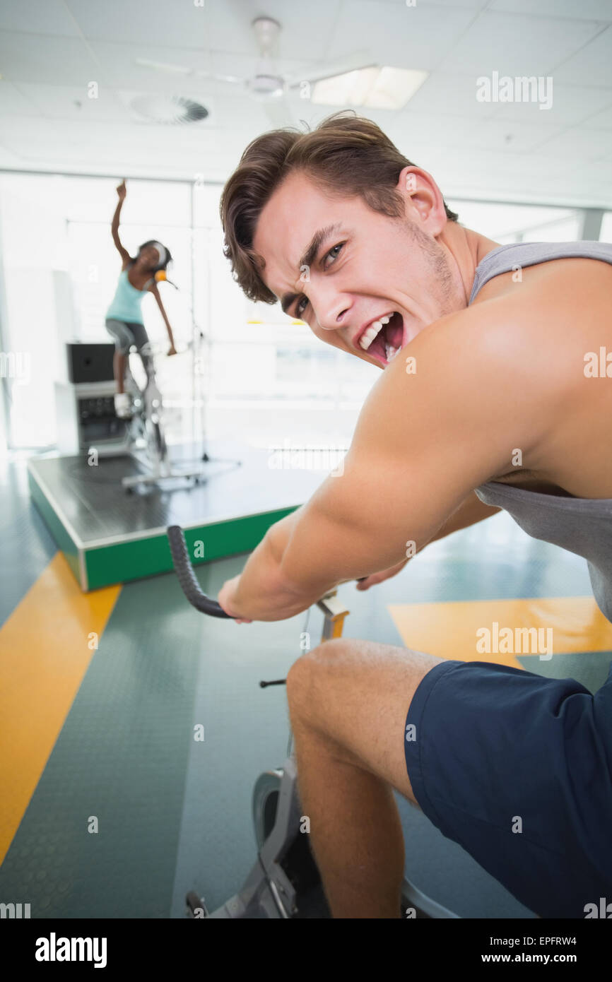 Handsome man smiling at camera in spin class Stock Photo - Alamy