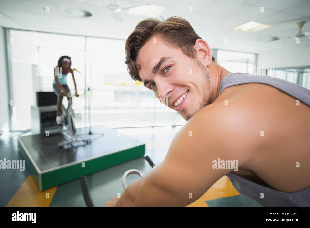 Handsome man smiling at camera in spin class Stock Photo - Alamy