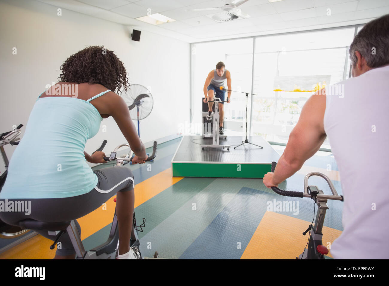 Spin class working out with motivational instructor Stock Photo - Alamy