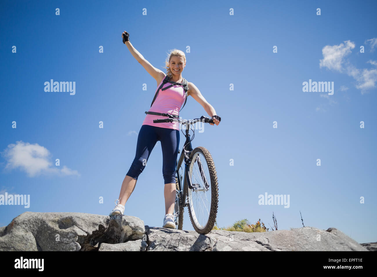 Fit pretty cyclist on a rocky terrain smiling at camera Stock Photo - Alamy
