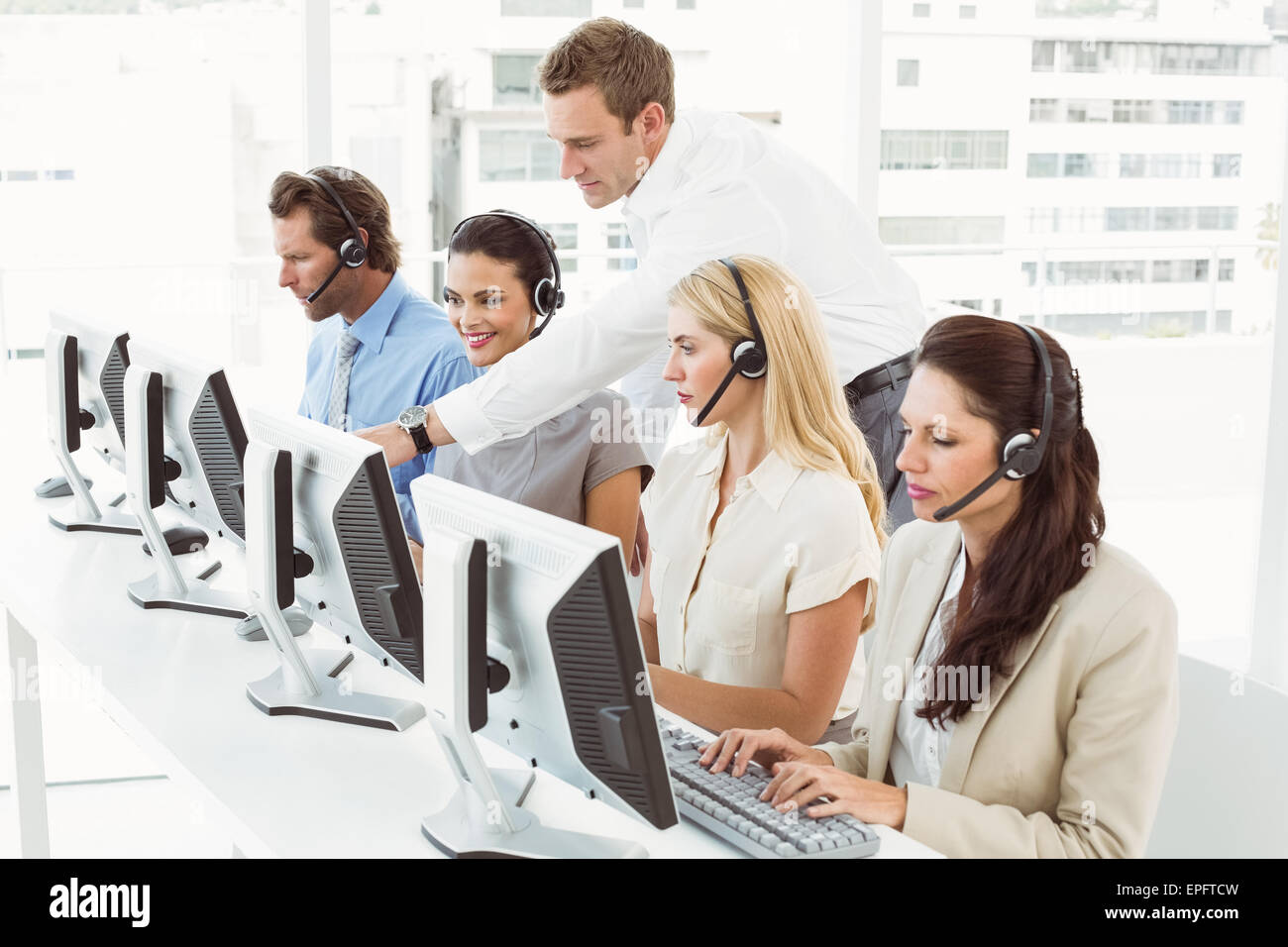 Business people with headsets using computers in office Stock Photo - Alamy