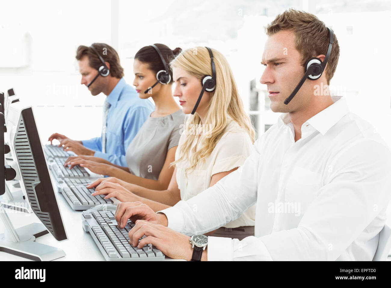 Business people with headsets using computers in office Stock Photo - Alamy