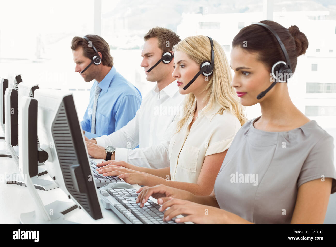 Business people with headsets using computers in office Stock Photo - Alamy
