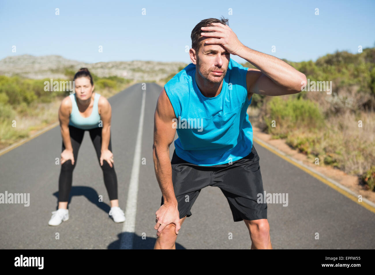 Fit couple jogging on the open road together Stock Photo - Alamy