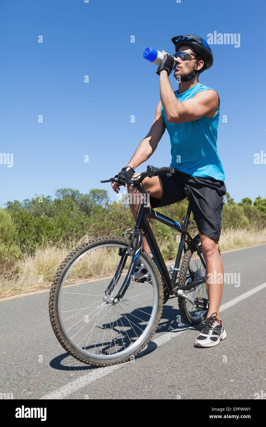 Handsome cyclist taking a break on his bike drinking water Stock Photo ...