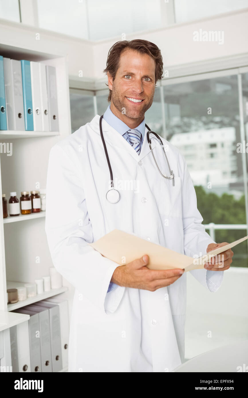 Confident smiling doctor with reports at medical office Stock Photo - Alamy