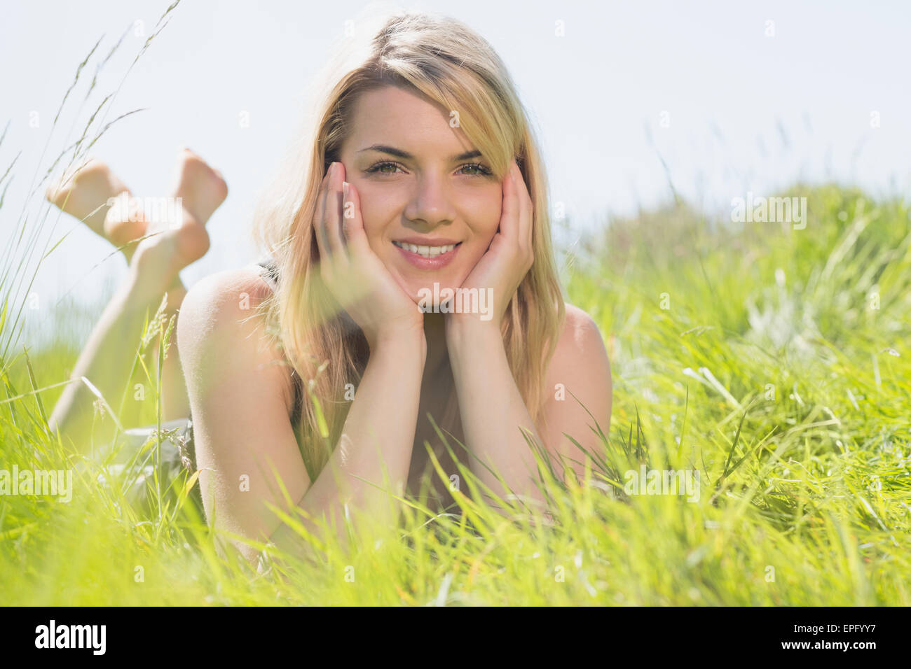 Pretty blonde in sundress lying on grass smiling at camera Stock Photo ...