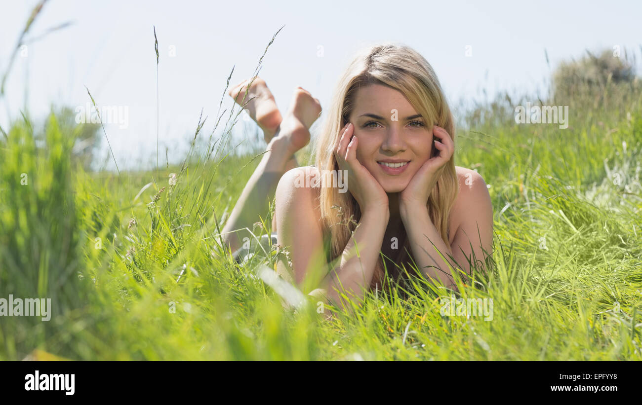 Pretty blonde in sundress lying on grass smiling at camera Stock Photo ...