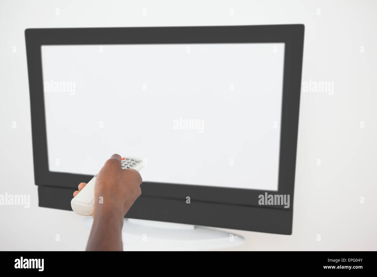 Hand holding remote and changing channel Stock Photo - Alamy