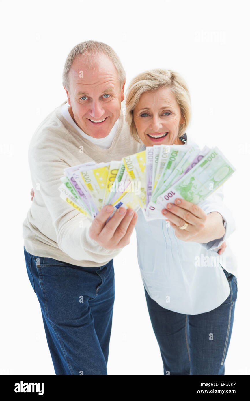 Happy mature couple smiling at camera showing money Stock Photo - Alamy