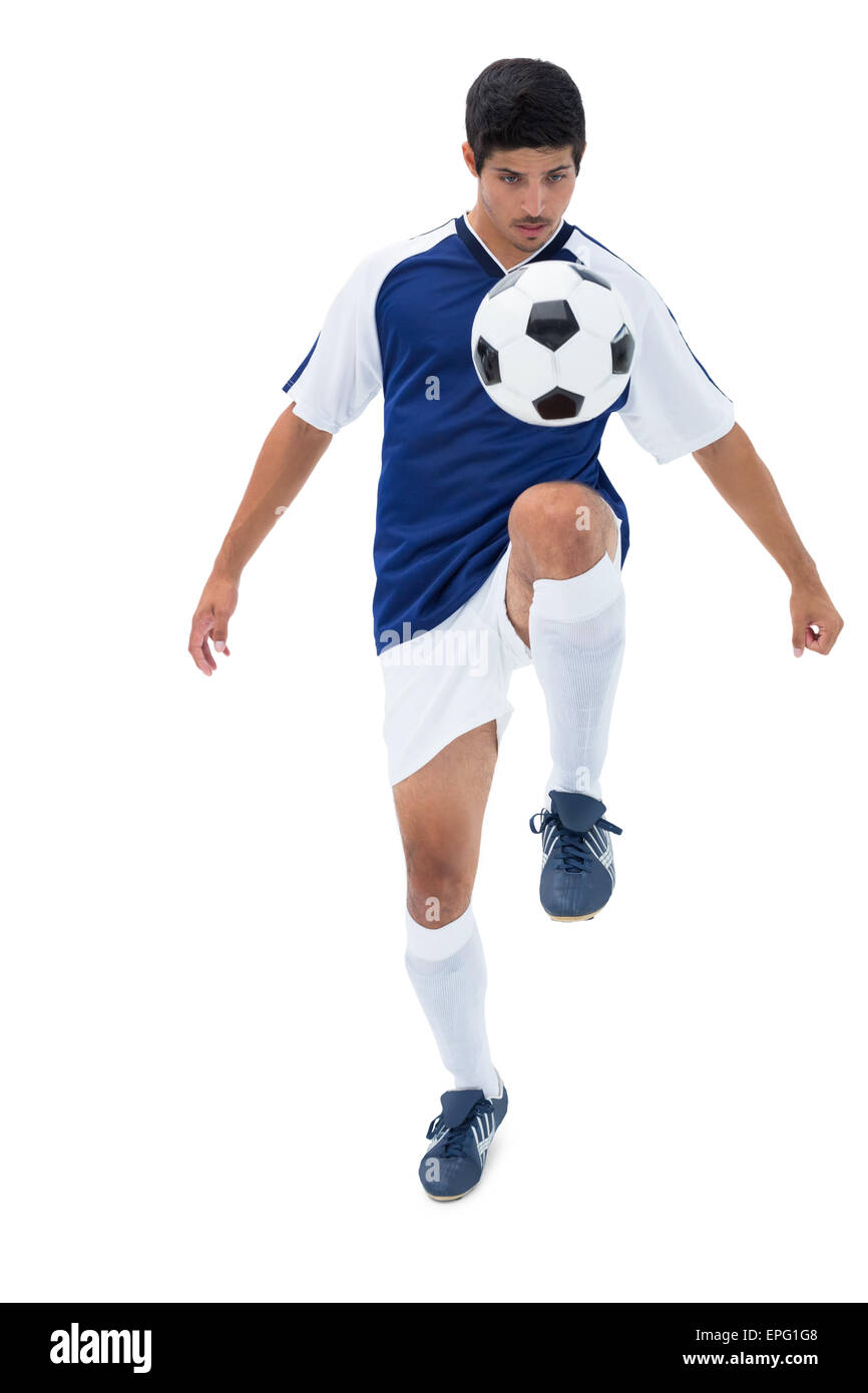 Football player in blue kicking ball Stock Photo - Alamy