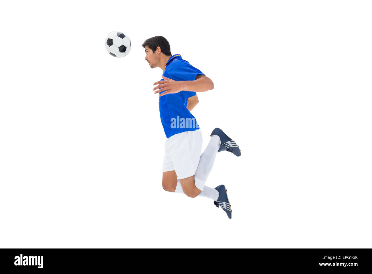 Football player in blue jumping to ball Stock Photo - Alamy