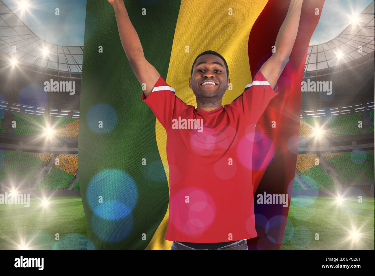 Composite image of excited handsome football fan cheering holding ghana ...