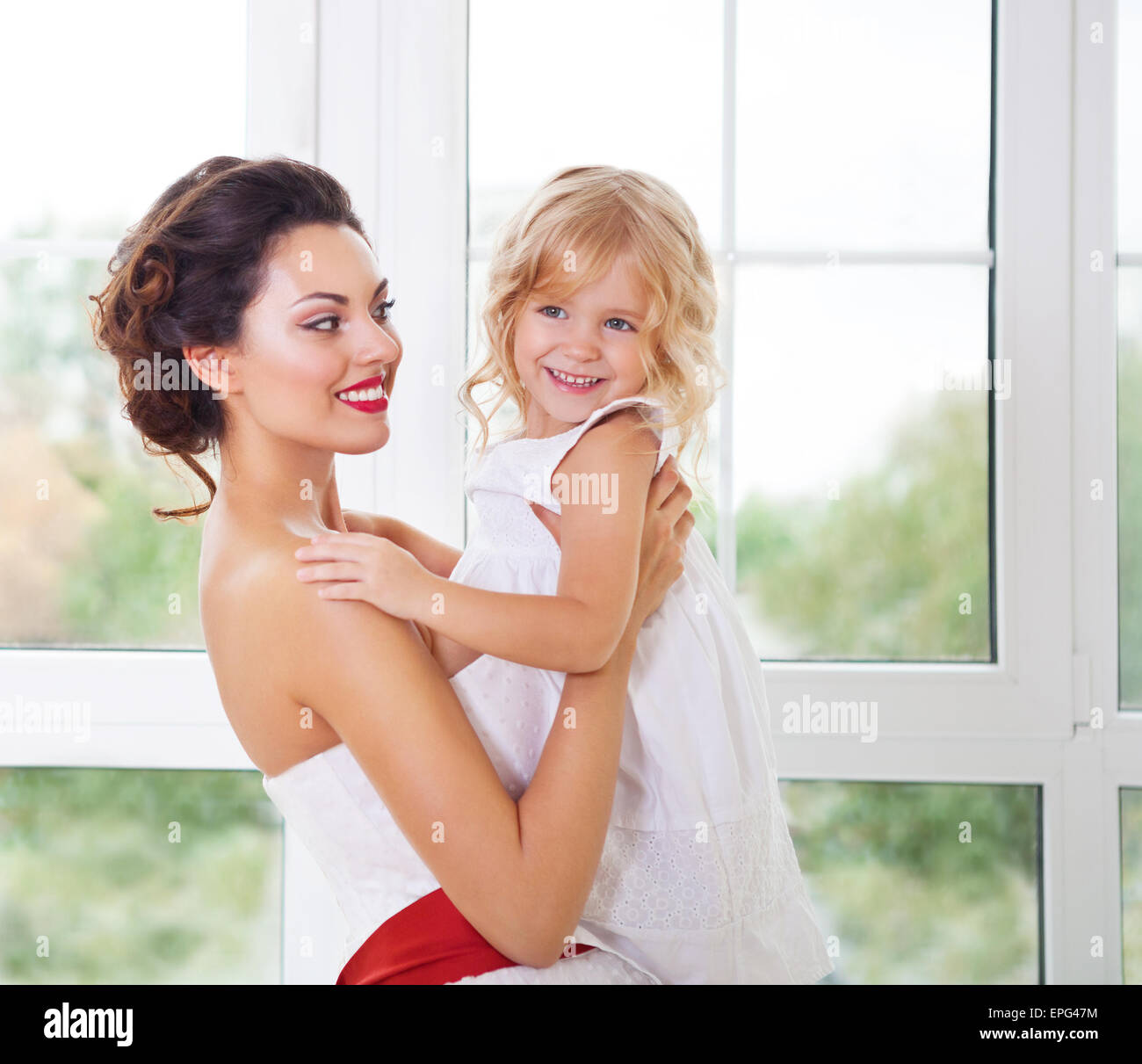 Smiling happy bride and a flower girl indoors Stock Photo - Alamy