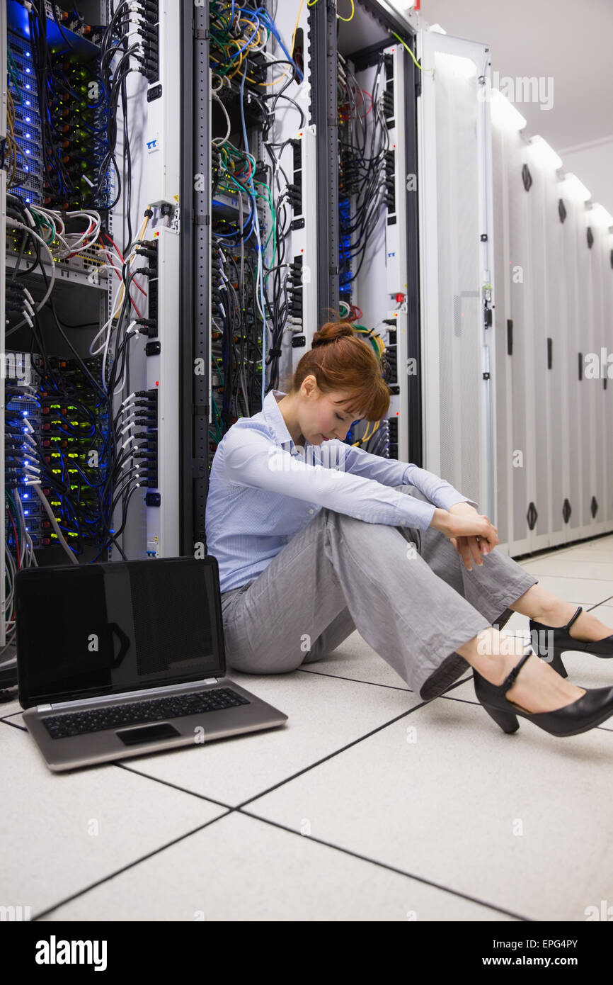 Stressed technician sitting on floor beside open server Stock Photo - Alamy