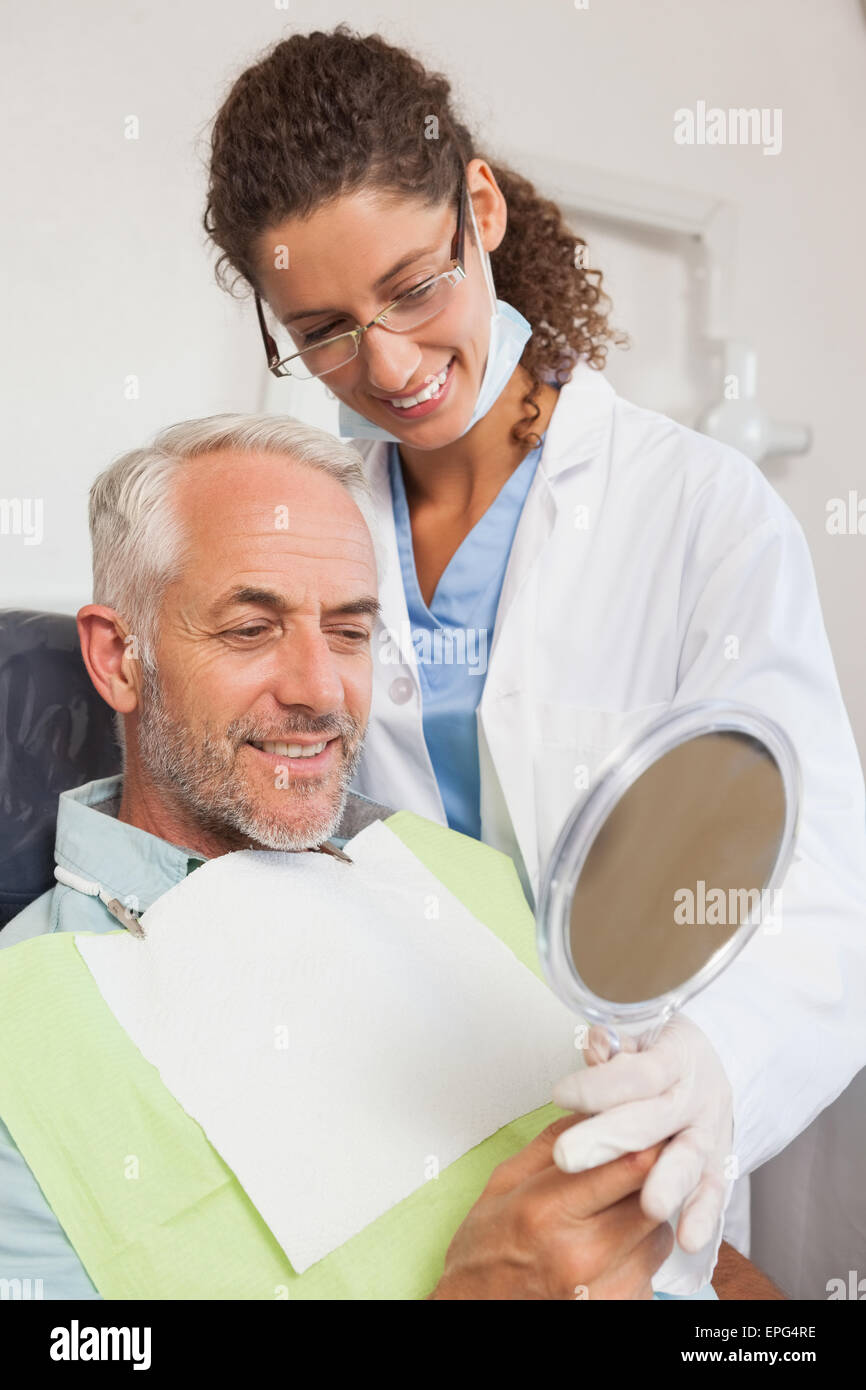 Patient admiring his new smile in the mirror Stock Photo - Alamy