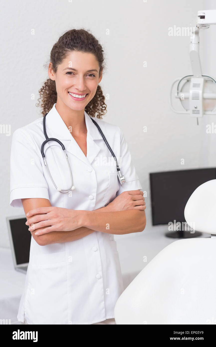 Dental assistant smiling at camera beside chair Stock Photo - Alamy