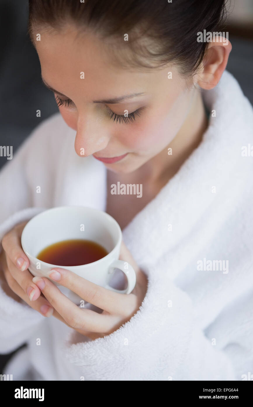 Beautiful woman in bathrobe having tea Stock Photo - Alamy
