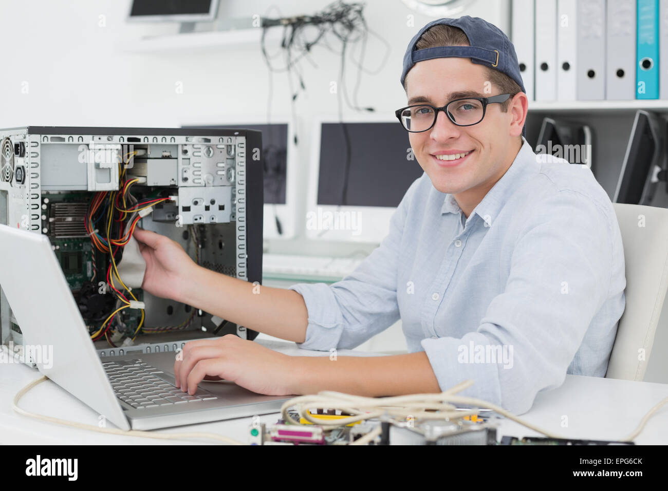 Computer engineer working on broken console with laptop Stock Photo - Alamy