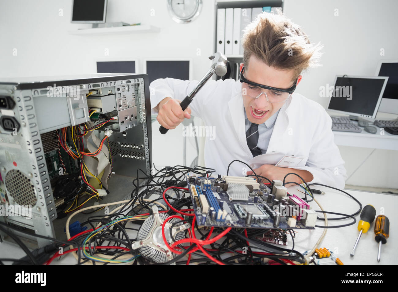 Angry computer engineer holding hammer over console Stock Photo - Alamy