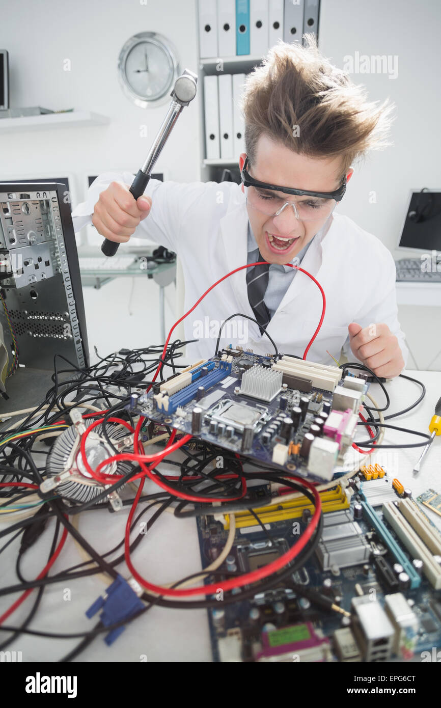 Angry computer engineer holding hammer over console Stock Photo - Alamy