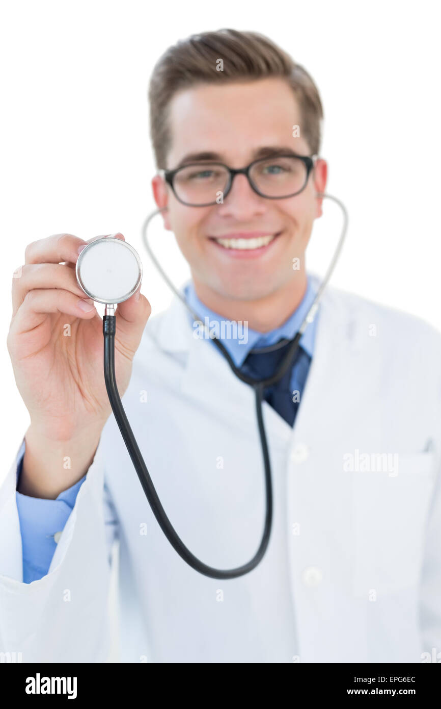 Smiling young doctor holding up stethoscope Stock Photo - Alamy