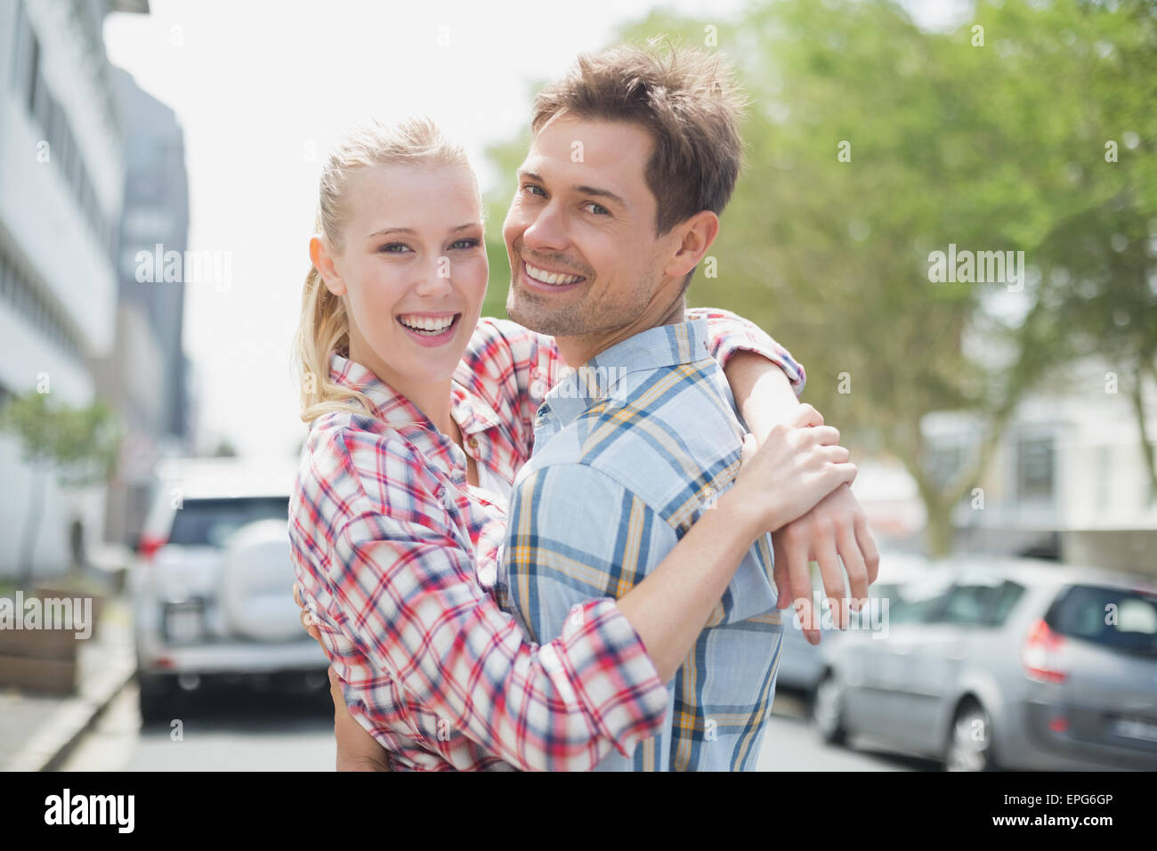 Couple in check shirts and denim hugging each other Stock Photo - Alamy