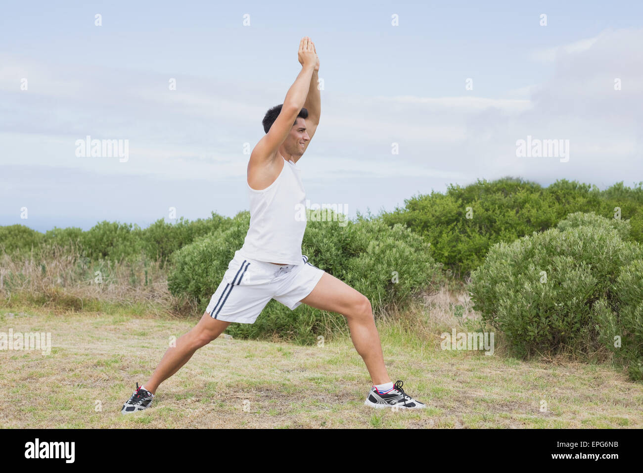 Man doing stretching exercises on countryside landscape Stock Photo - Alamy