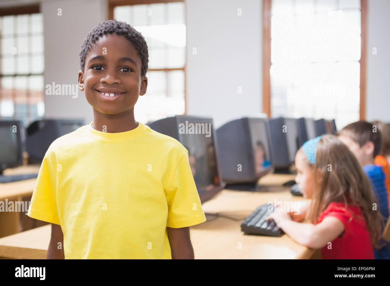 Cute pupil in computer class smiling at camera Stock Photo - Alamy