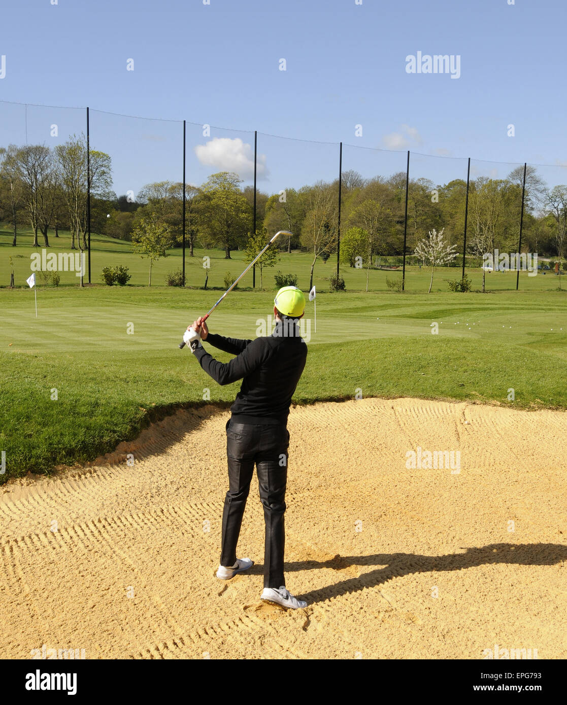 Male Golfer playing from a Bunker at the Practice Ground at Sundridge ...