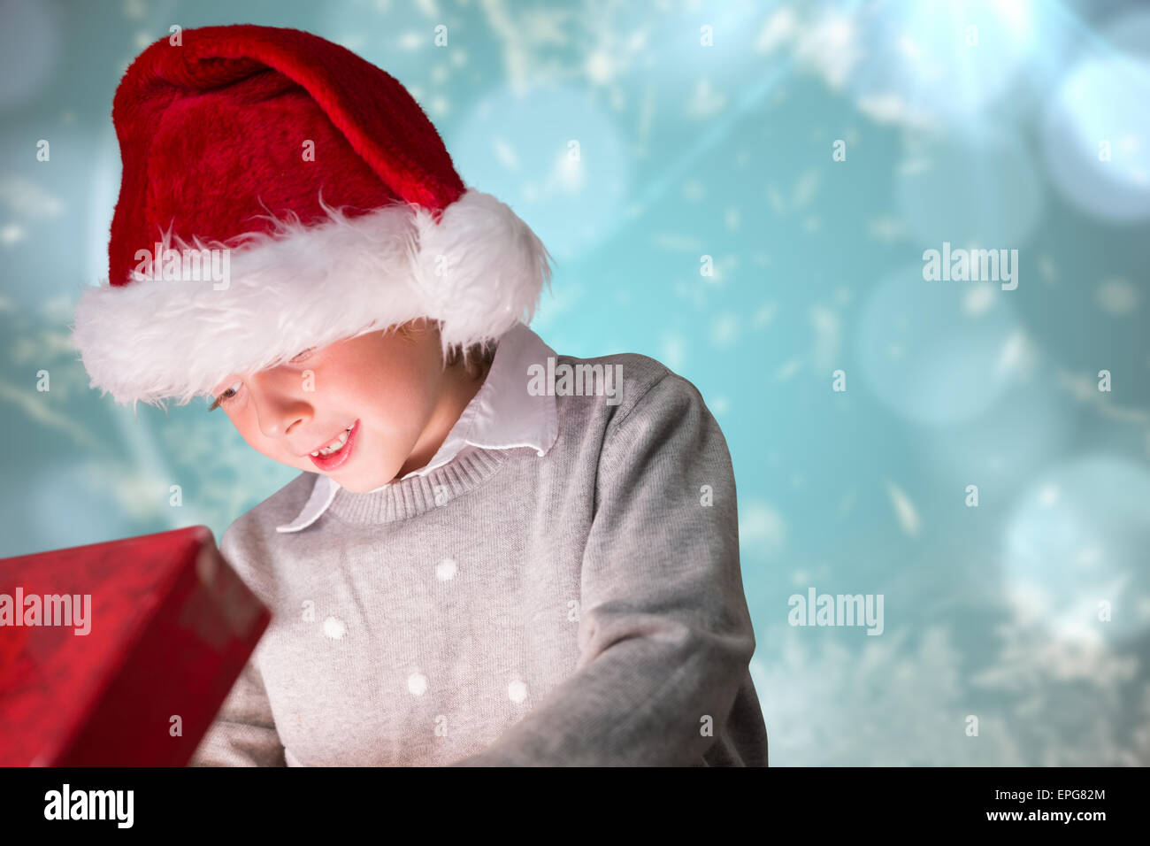 Composite image of festive boy opening gift Stock Photo - Alamy