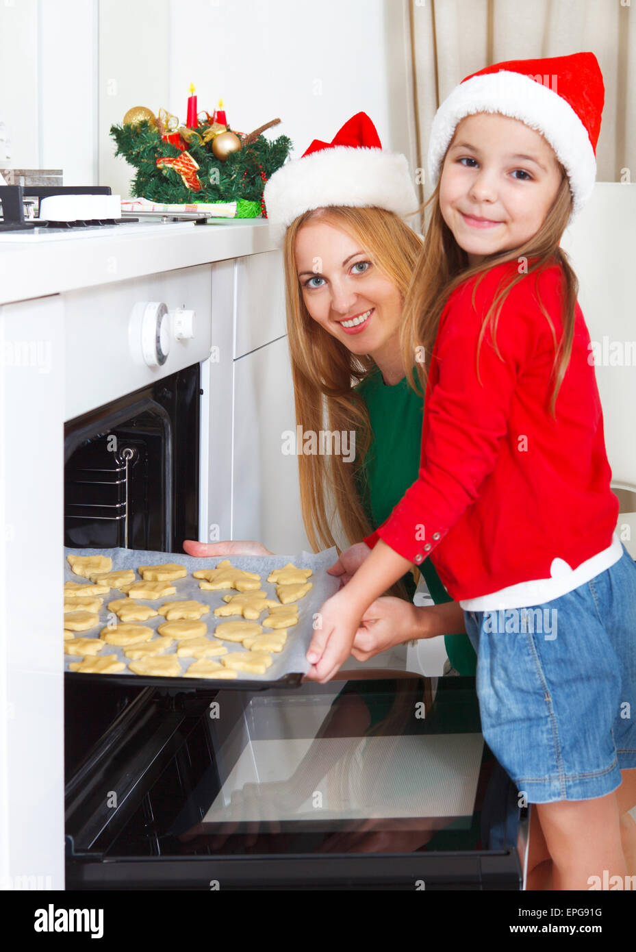 Little girl with her mother baking Christmas cookies Stock Photo - Alamy