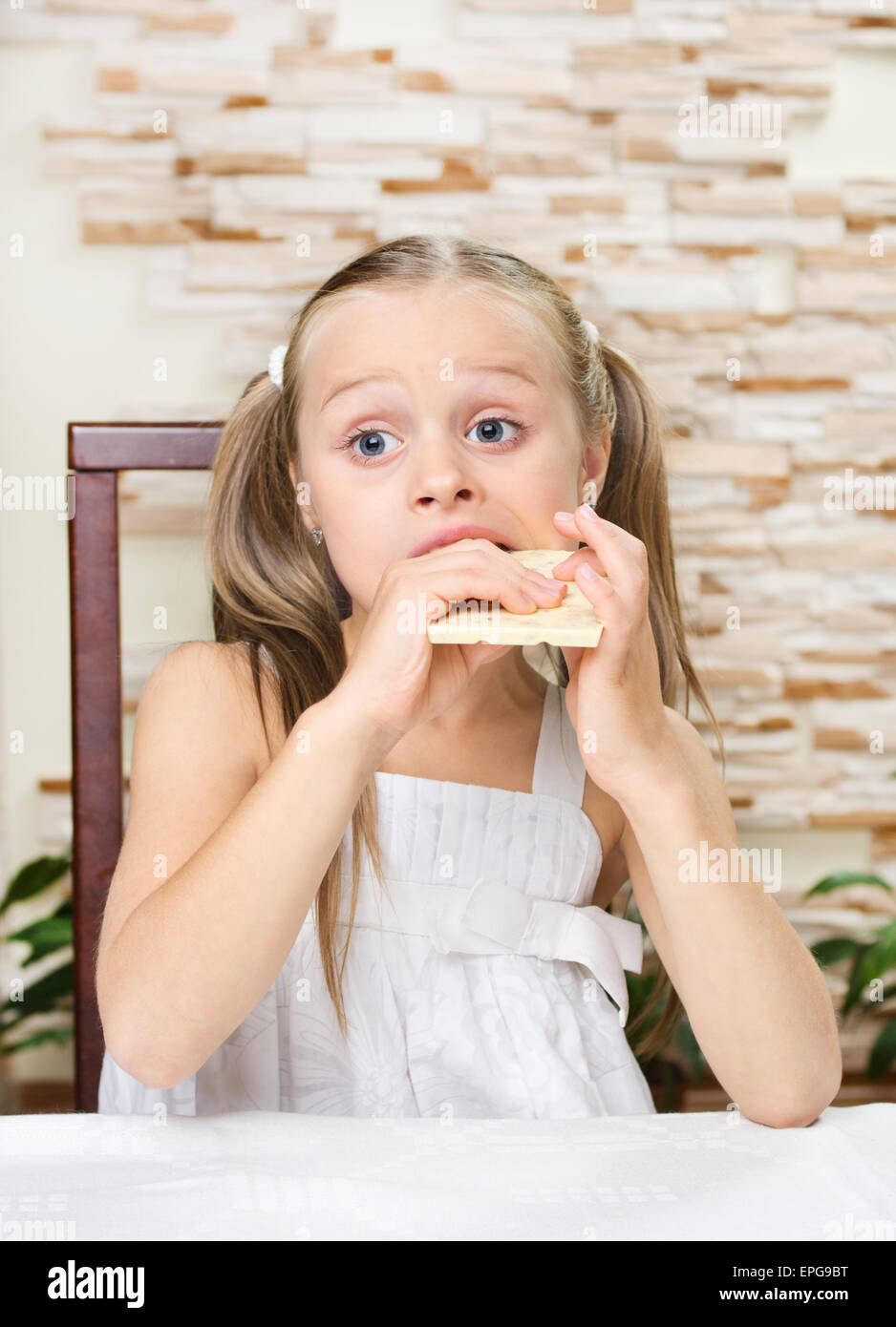 Little girl eat chocolate at room Stock Photo - Alamy