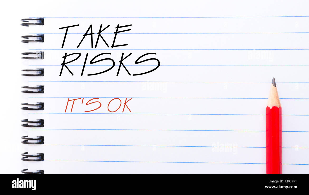 Take Risks, It Is OK Text written on notebook page, red pencil on the ...