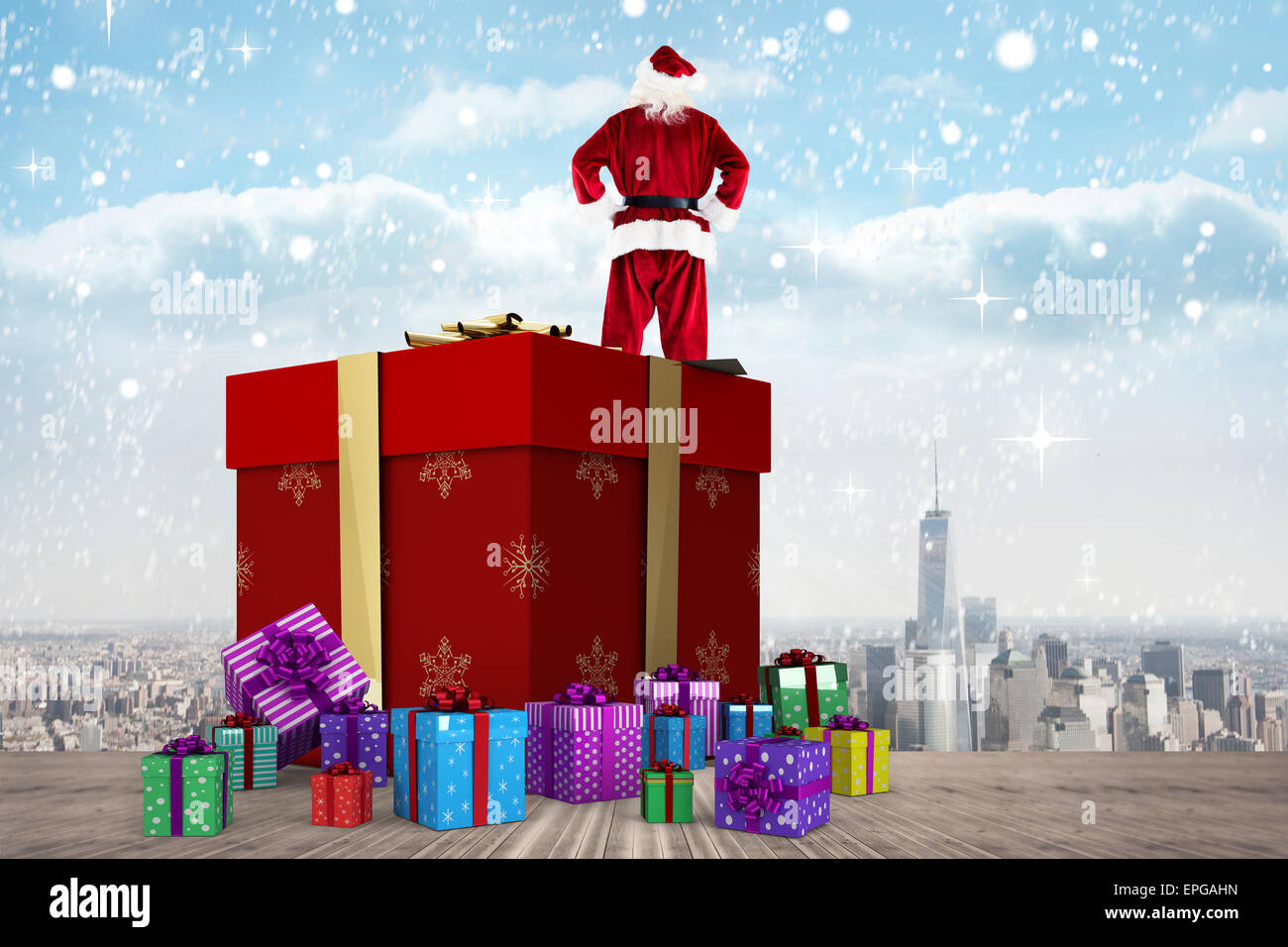 Composite image of santa standing on giant present Stock Photo - Alamy