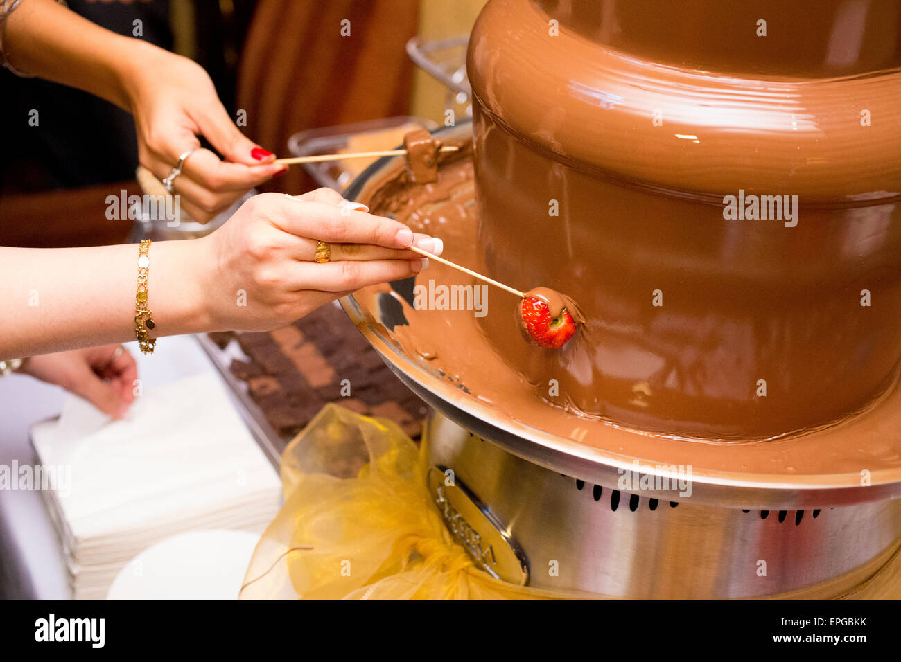 hands dipping snacks into a chocolate fountain Stock Photo - Alamy